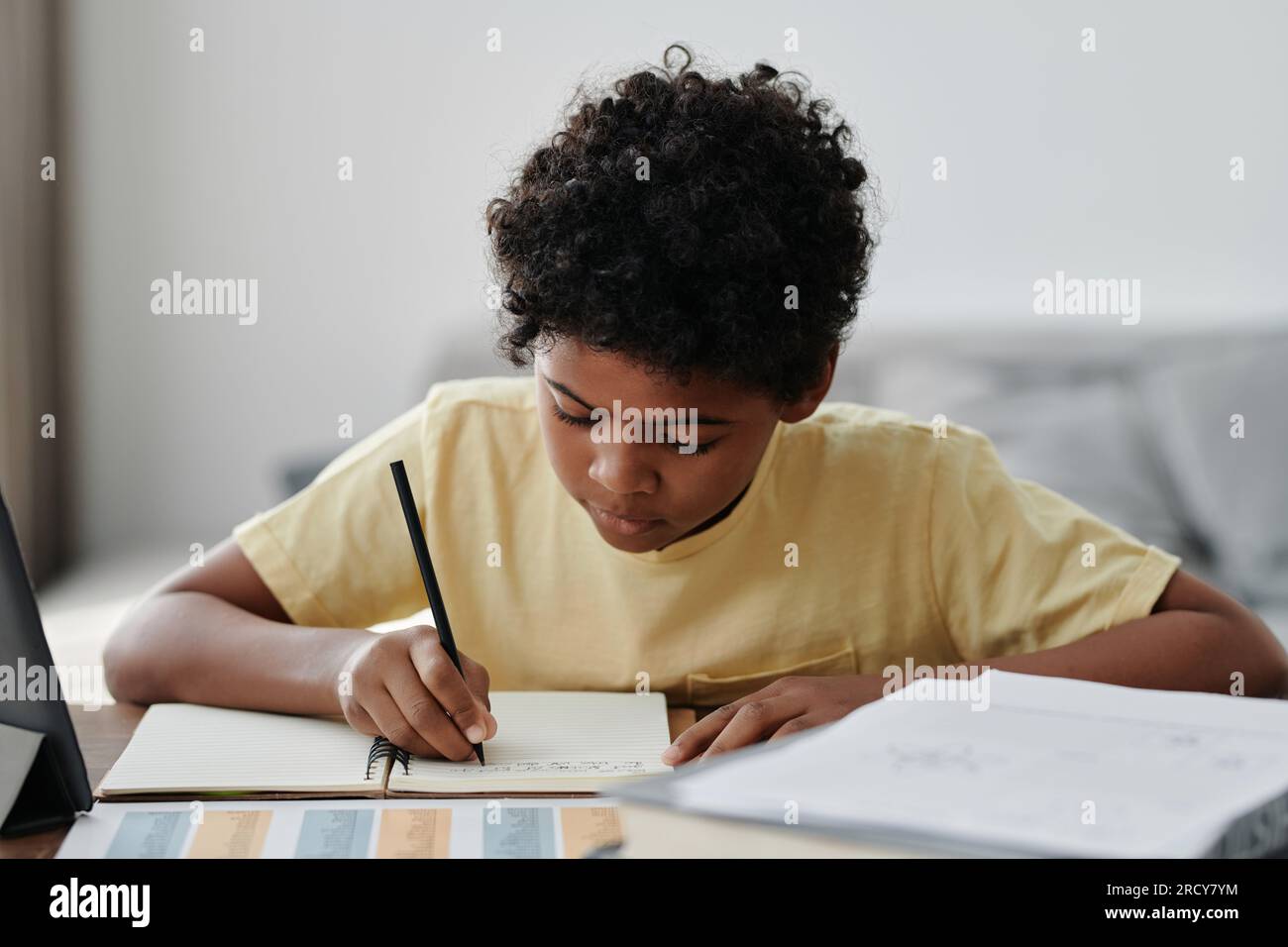 African American little boy doing homework at table at home Stock Photo ...