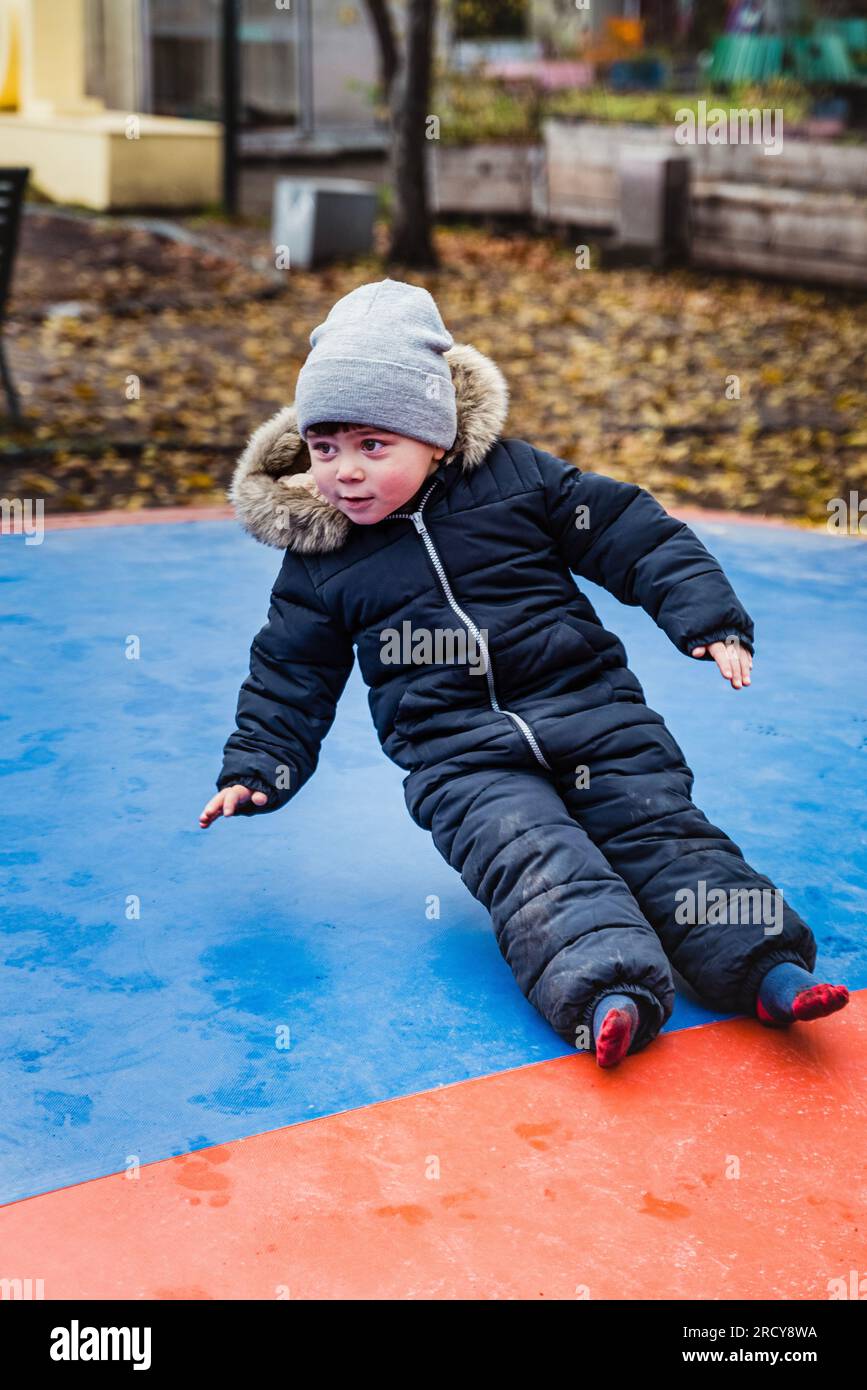 Falling child executes a side fall on an inflatable trampoline conveys ...