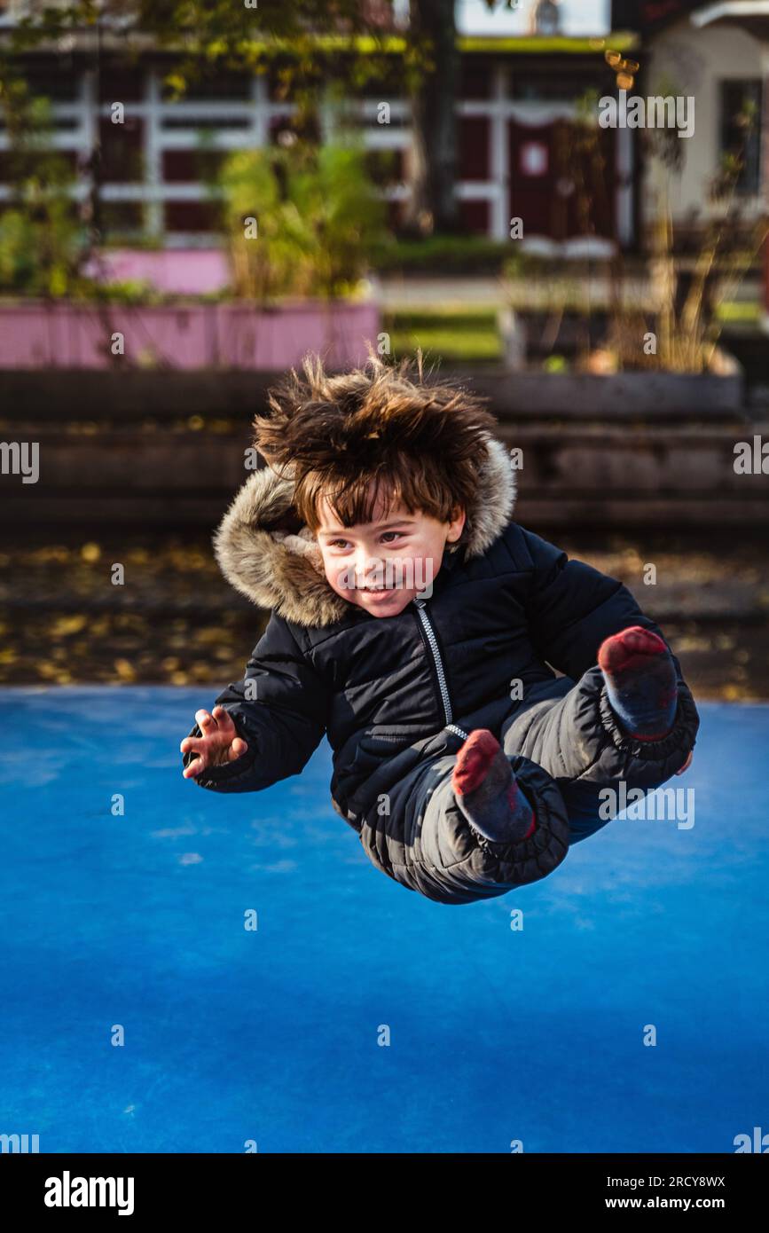 Cheerful boy or kid sitting in the air like jumping pole vault. Free ...