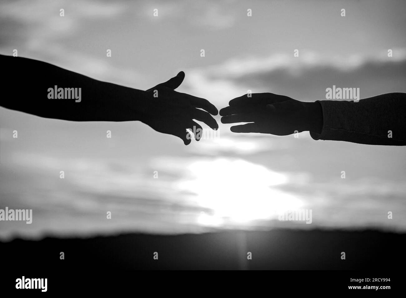 Helping hand sky background Black and White Stock Photos & Images - Alamy