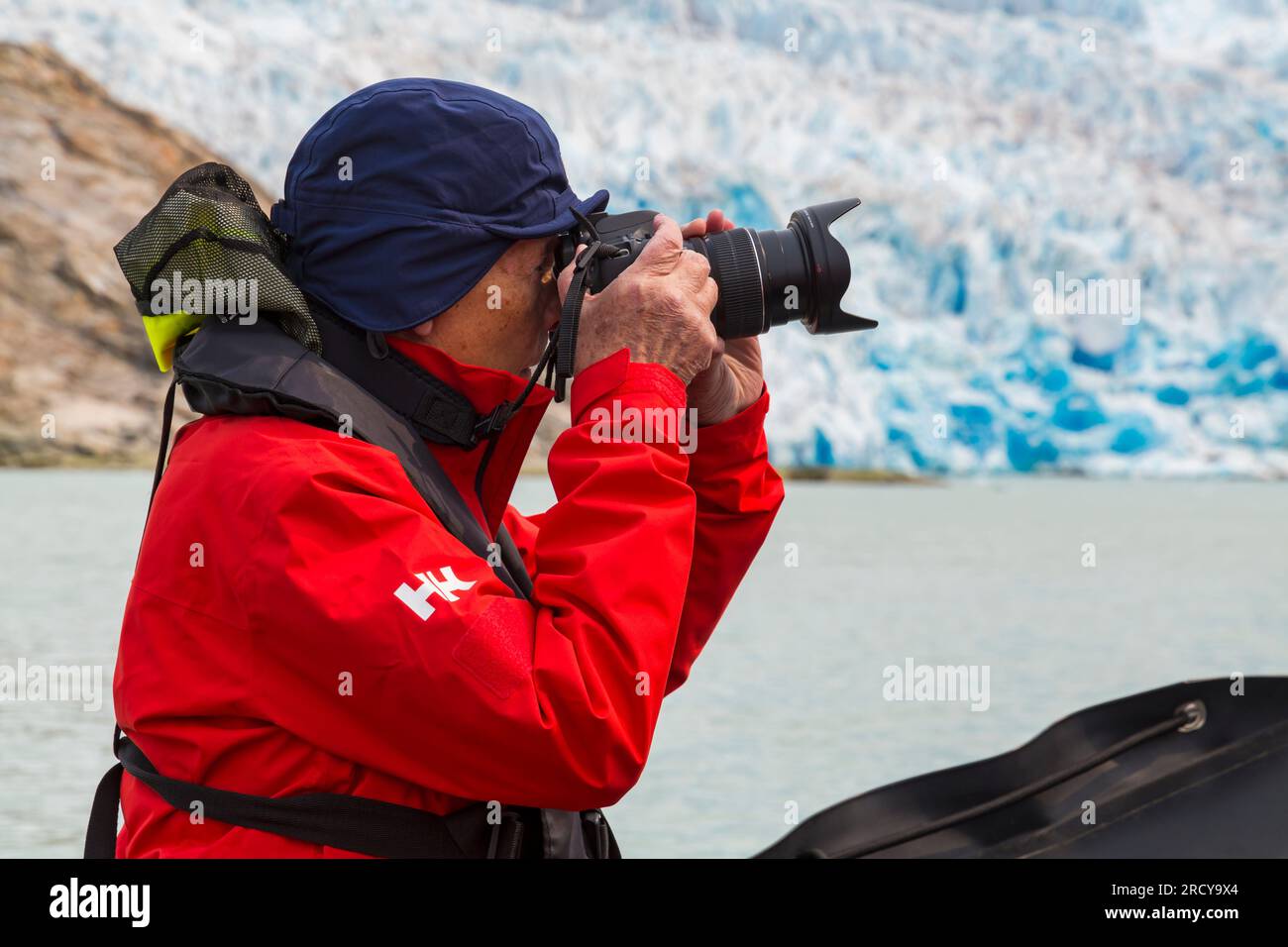 photographer tourist taking a photo with camera of glacier at ...