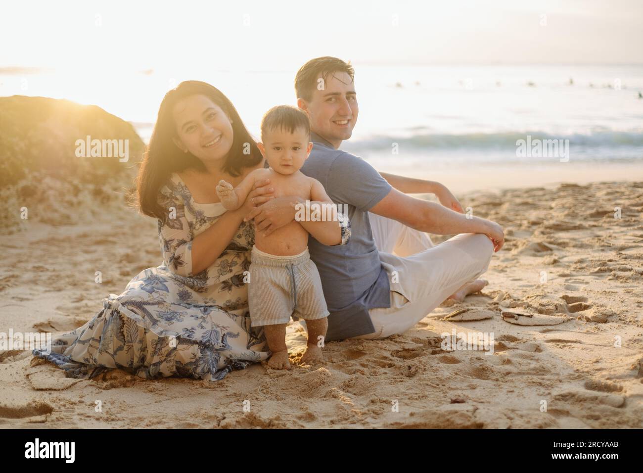 A happy family playing at the beach during golden hour in Bali ...
