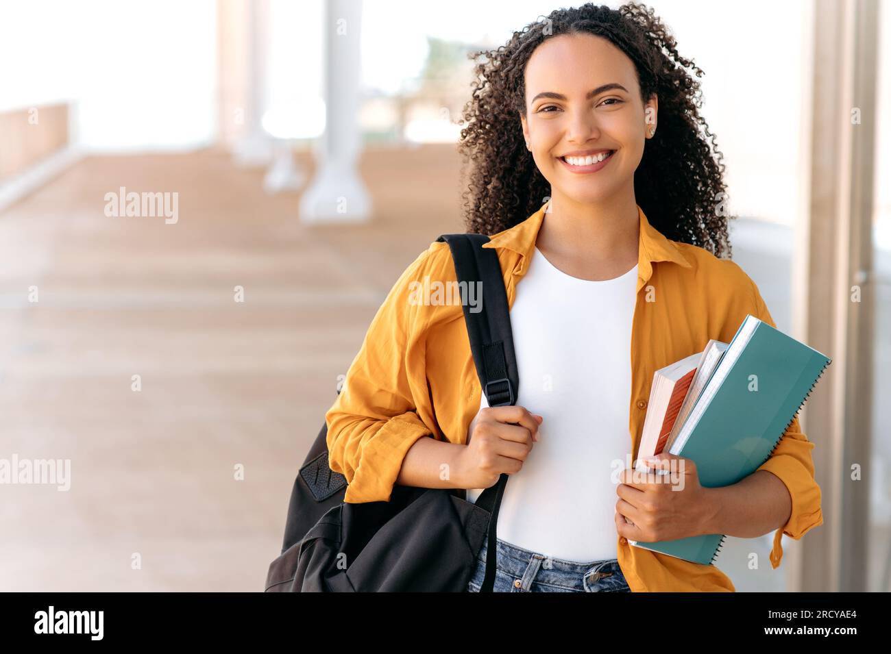 Close-up of a cheerful lovely curly haired brazilian or hispanic female ...
