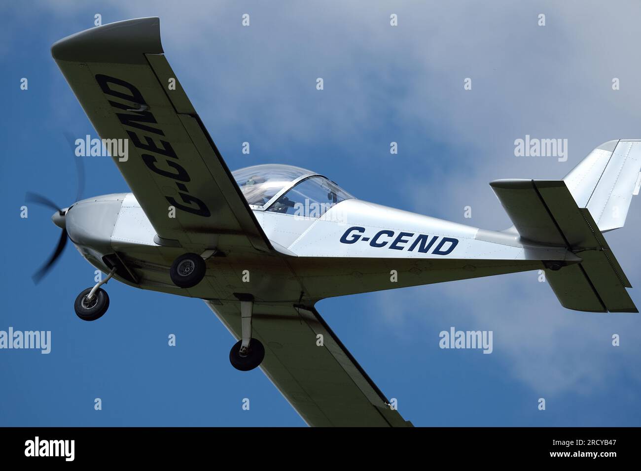 Low wing light monoplane in flight over local urban airfield. Evektor ...