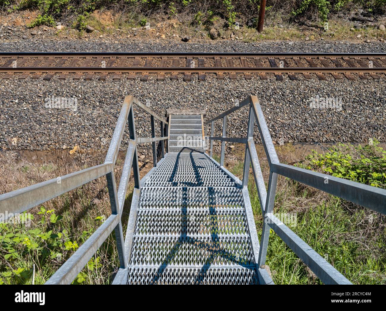 Metal stairs leading downward to railroad tracks Stock Photo - Alamy