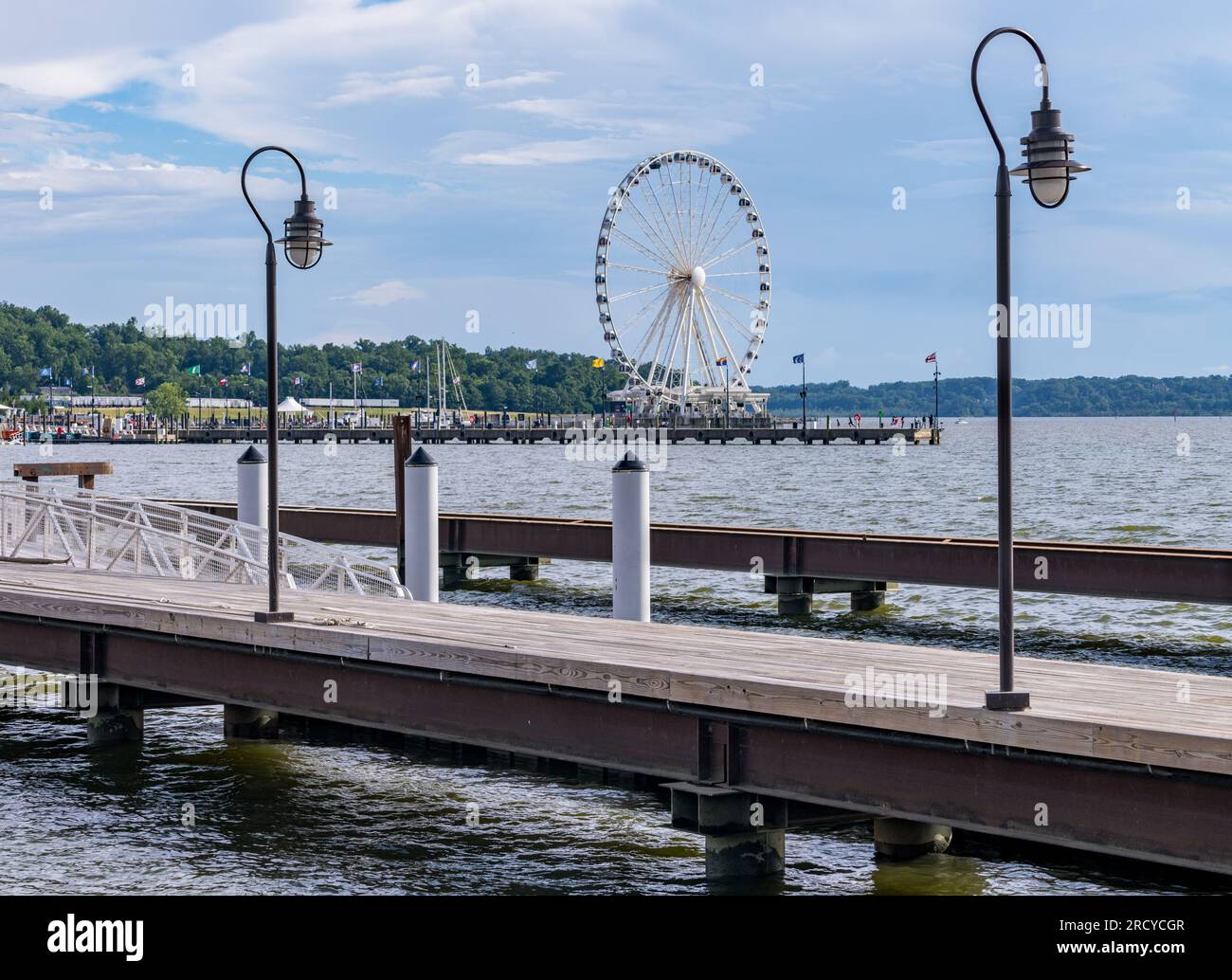 Wooden pier with the Ferris Wheel behind with skyline of National ...