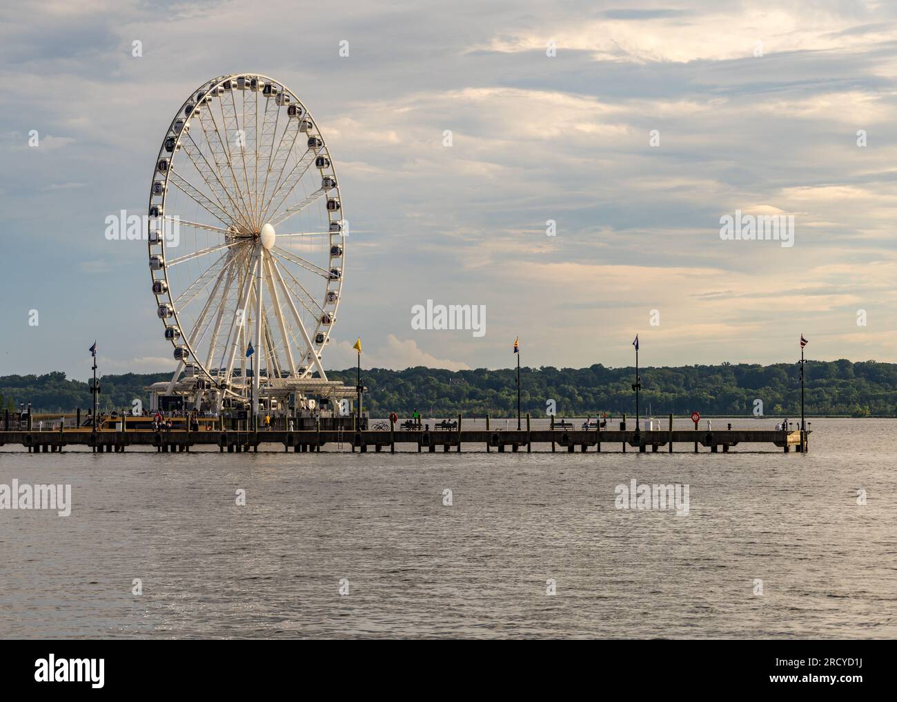 Wooden pier with the Ferris Wheel behind with skyline of National ...