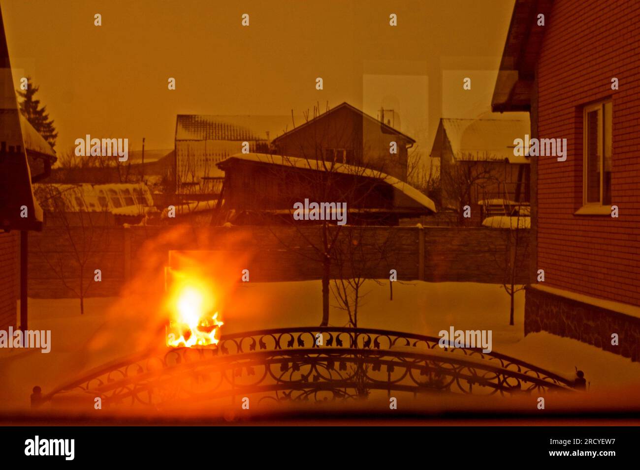 winter landscape outside the window with reflection of fire in the ...