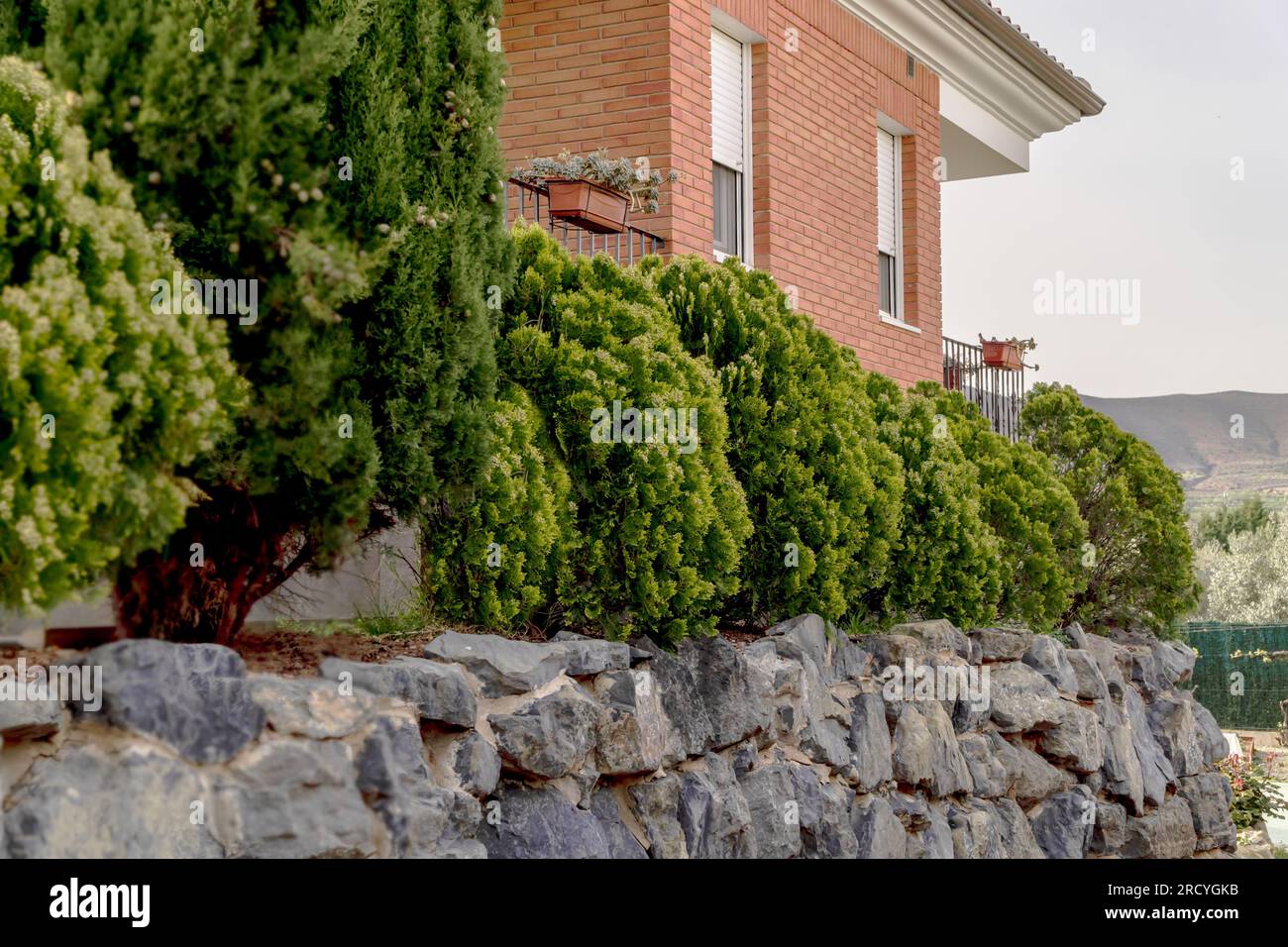 Private house windows with garden over a wall of rocks. Side view Stock ...