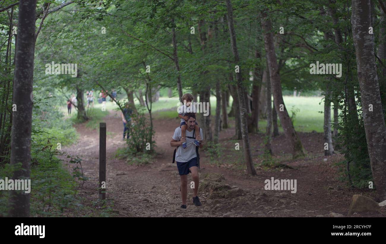 Father and child hiking together in nature son on dad shoulders Stock ...
