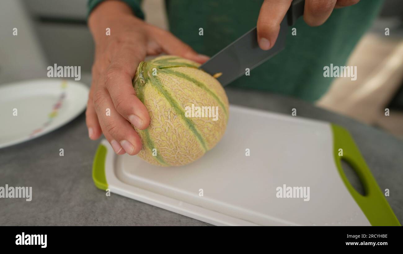 Hand cutting melong fruit closeup hands holding knife slicing healthy ...
