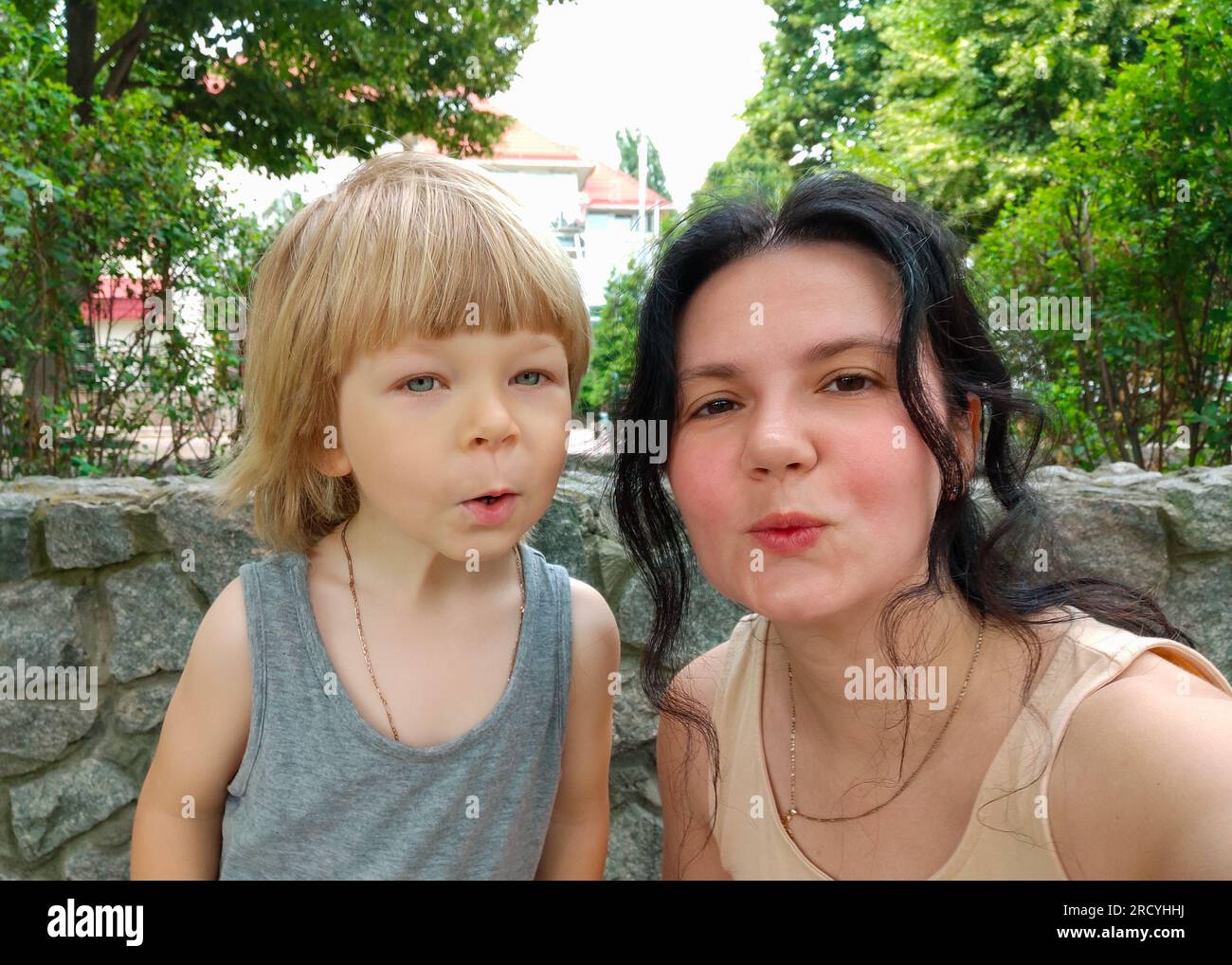 Mom and son smiling while looking at camera. young mother with dark ...