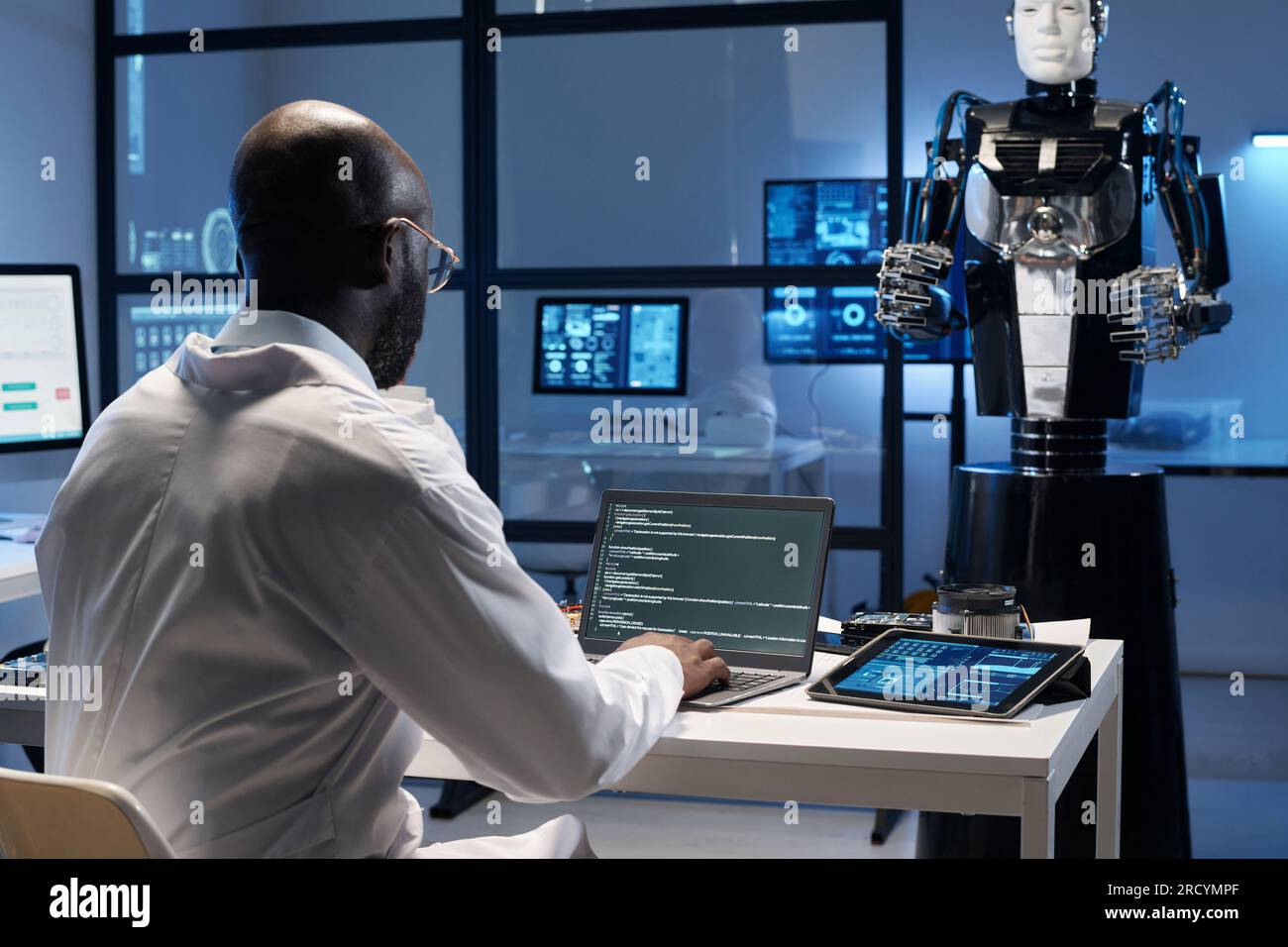 Rear view of African American engineer typing codes on computer in the ...