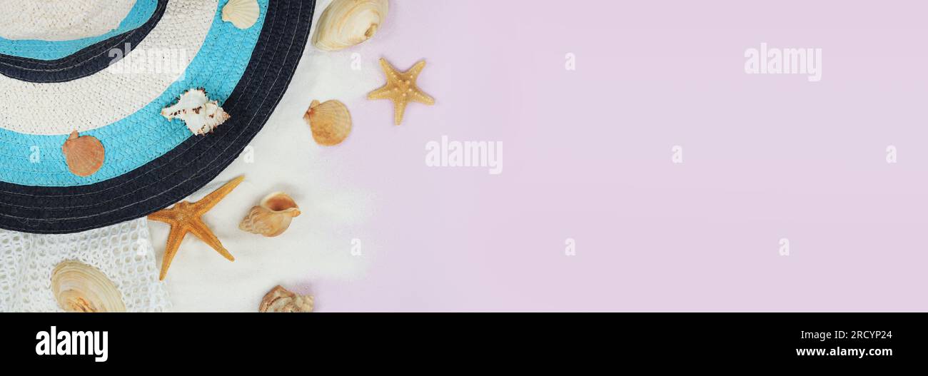 Beach hat, mesh and sand with seashells on a pink background in summer ...