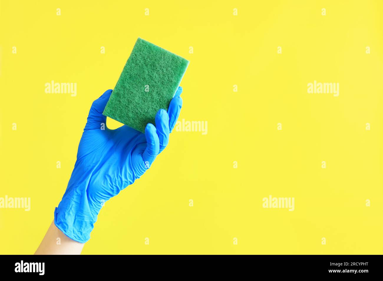A woman's hand in a glove holds a sponge for washing dishes. House ...
