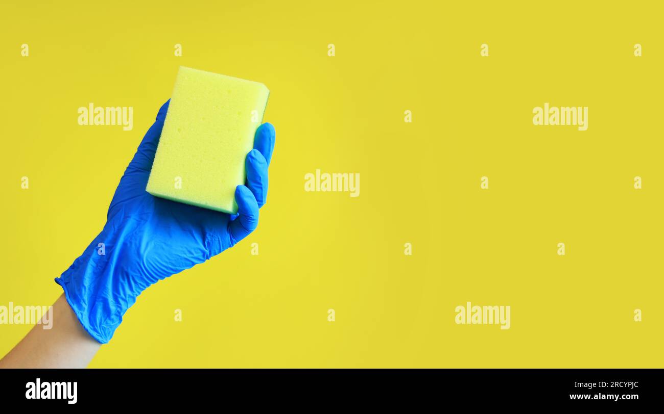 A woman's hand in a glove holds a sponge for washing dishes. House ...
