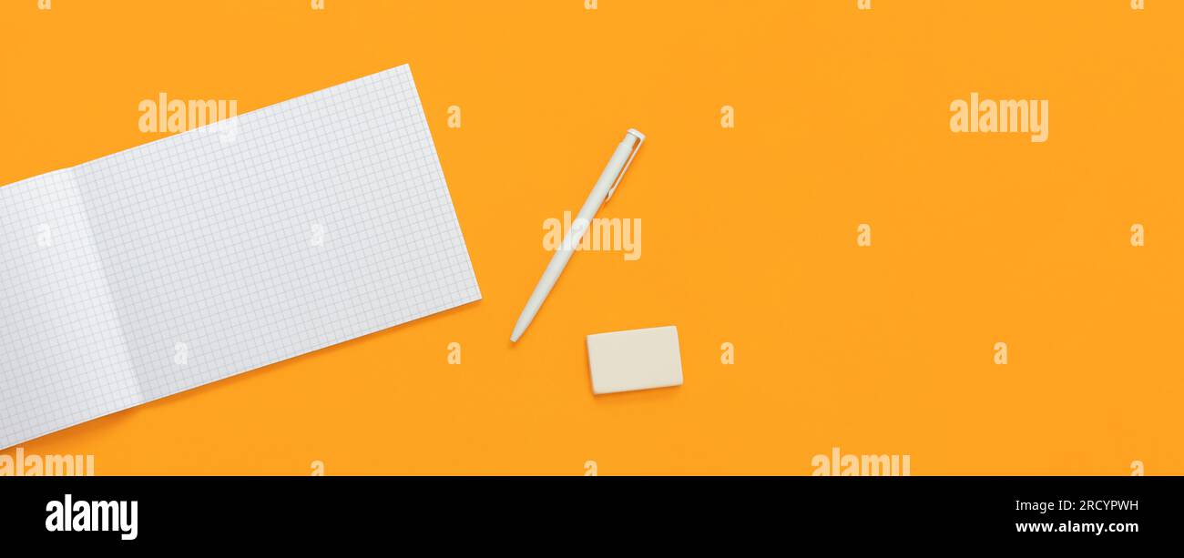 An open notebook with clean white sheets next to white pen and an ...