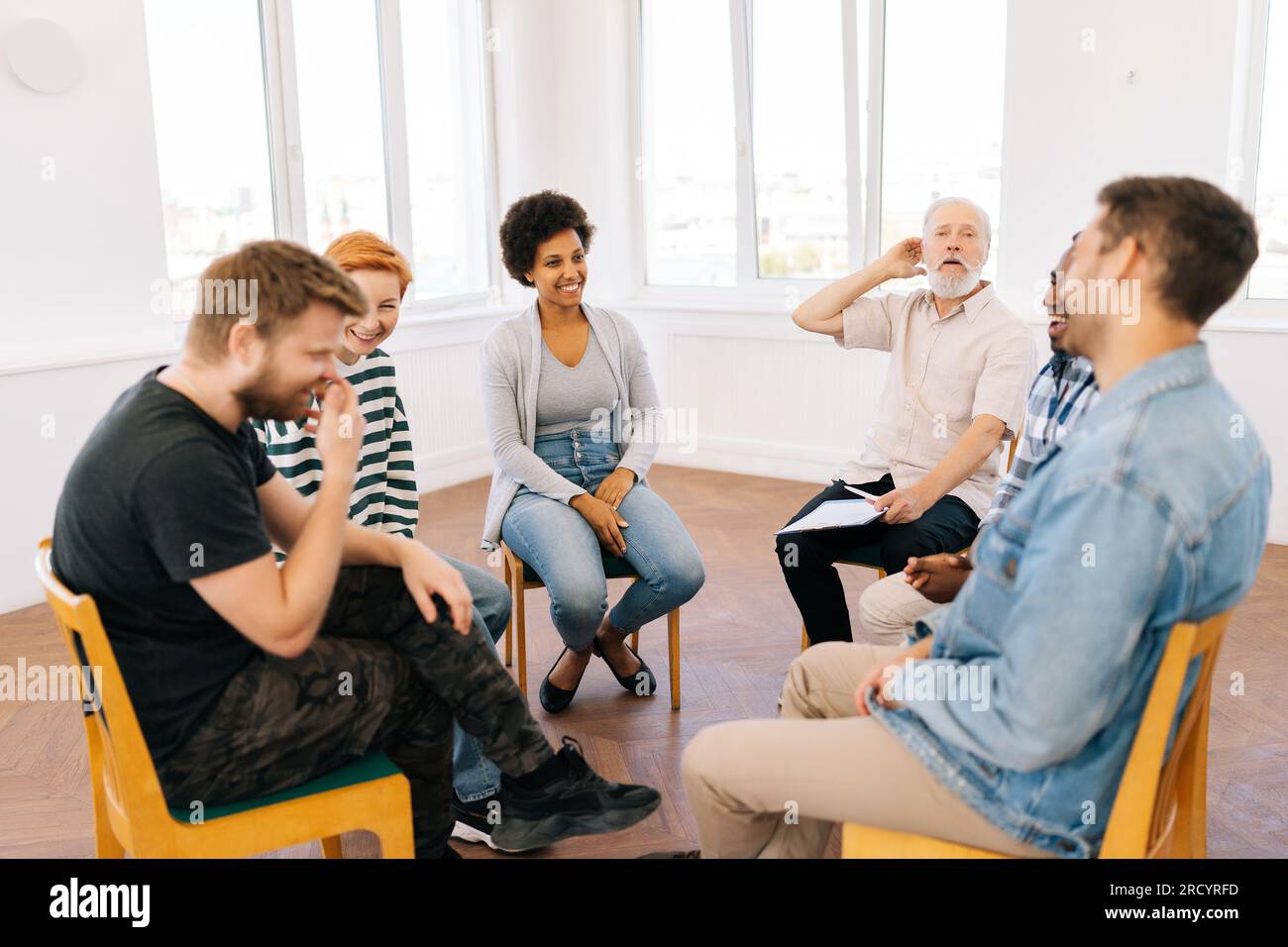 Wide shot of cheerful interracial group of people with alcohol ...