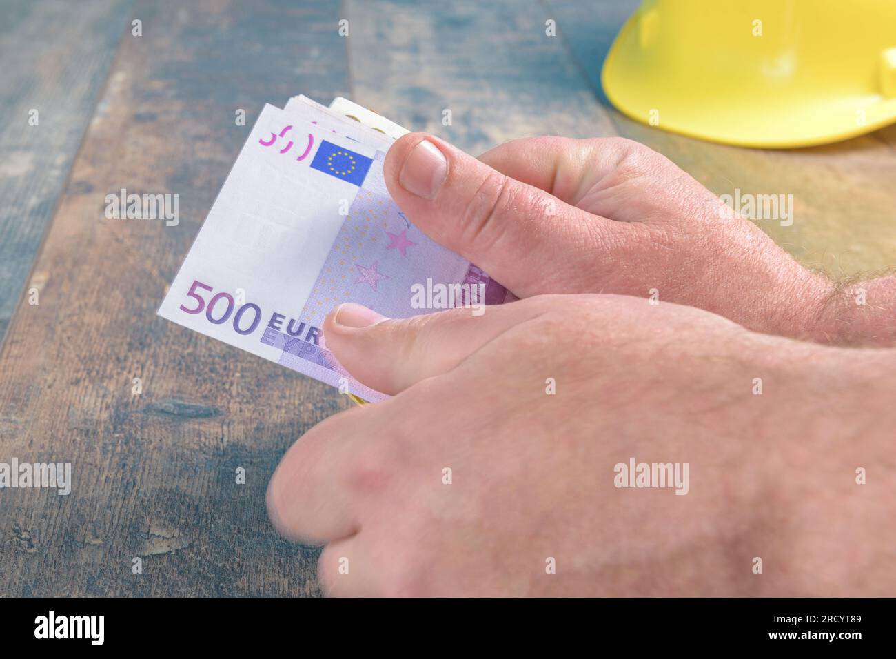 Euro banknotes in hands on wooden rustic background. Yellow ...