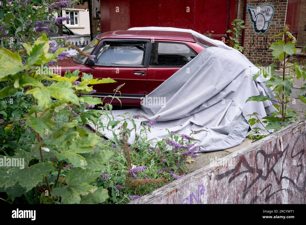 Two cars are stored off-road on overgrown private land in Tower Hamlets ...