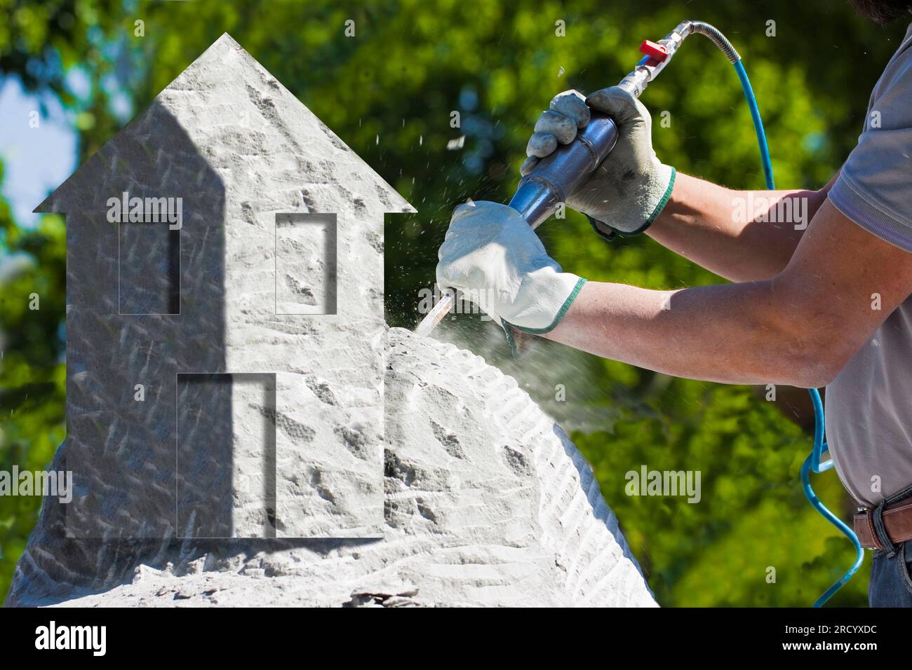 Man at work with compressed air chisel and protective gloves carving a ...
