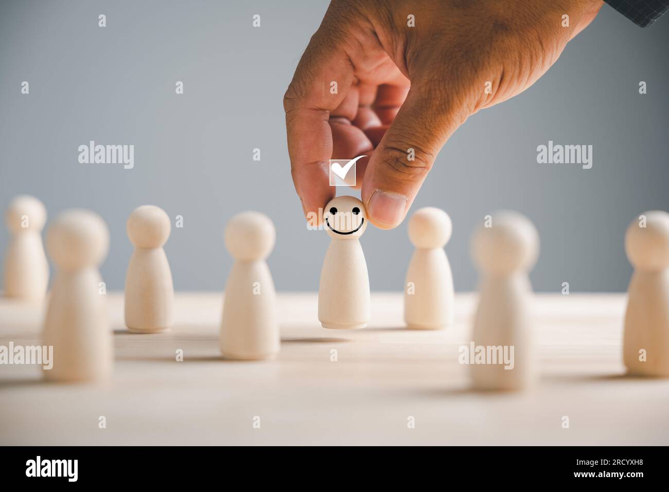 Hand choosing a wooden figure as the chosen leader from the crowd Stock ...