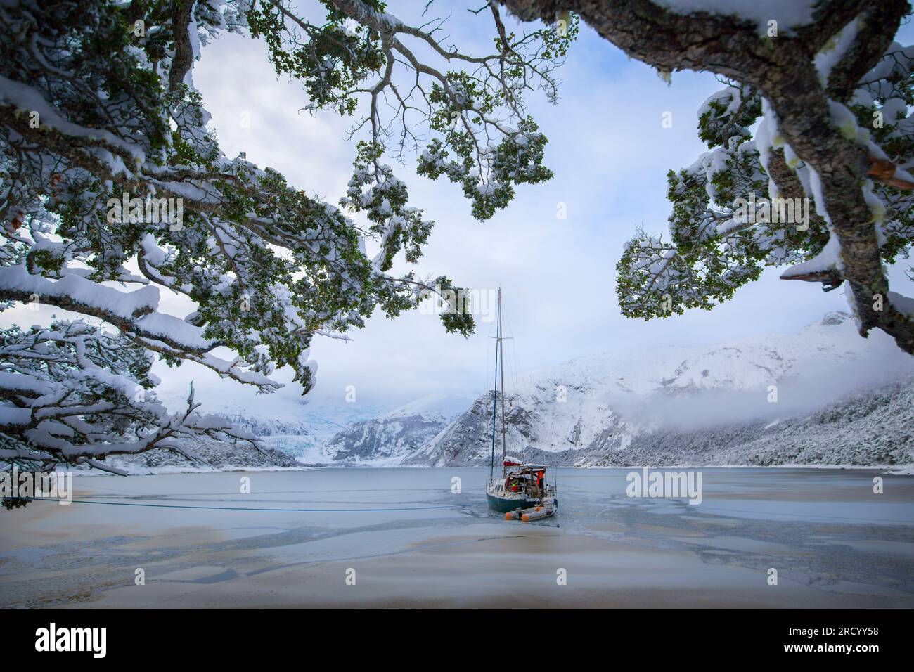 Sailboat covered in snow is anchored in the icy bay in Patagonia ...
