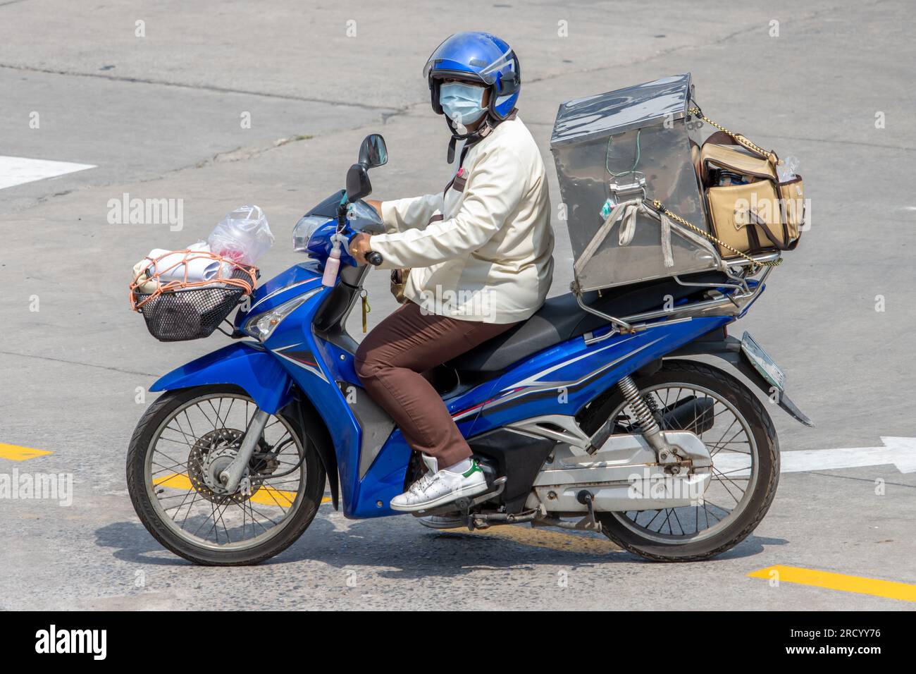 A man rides a motorcycle with a metal storage box, Thailand Stock Photo ...