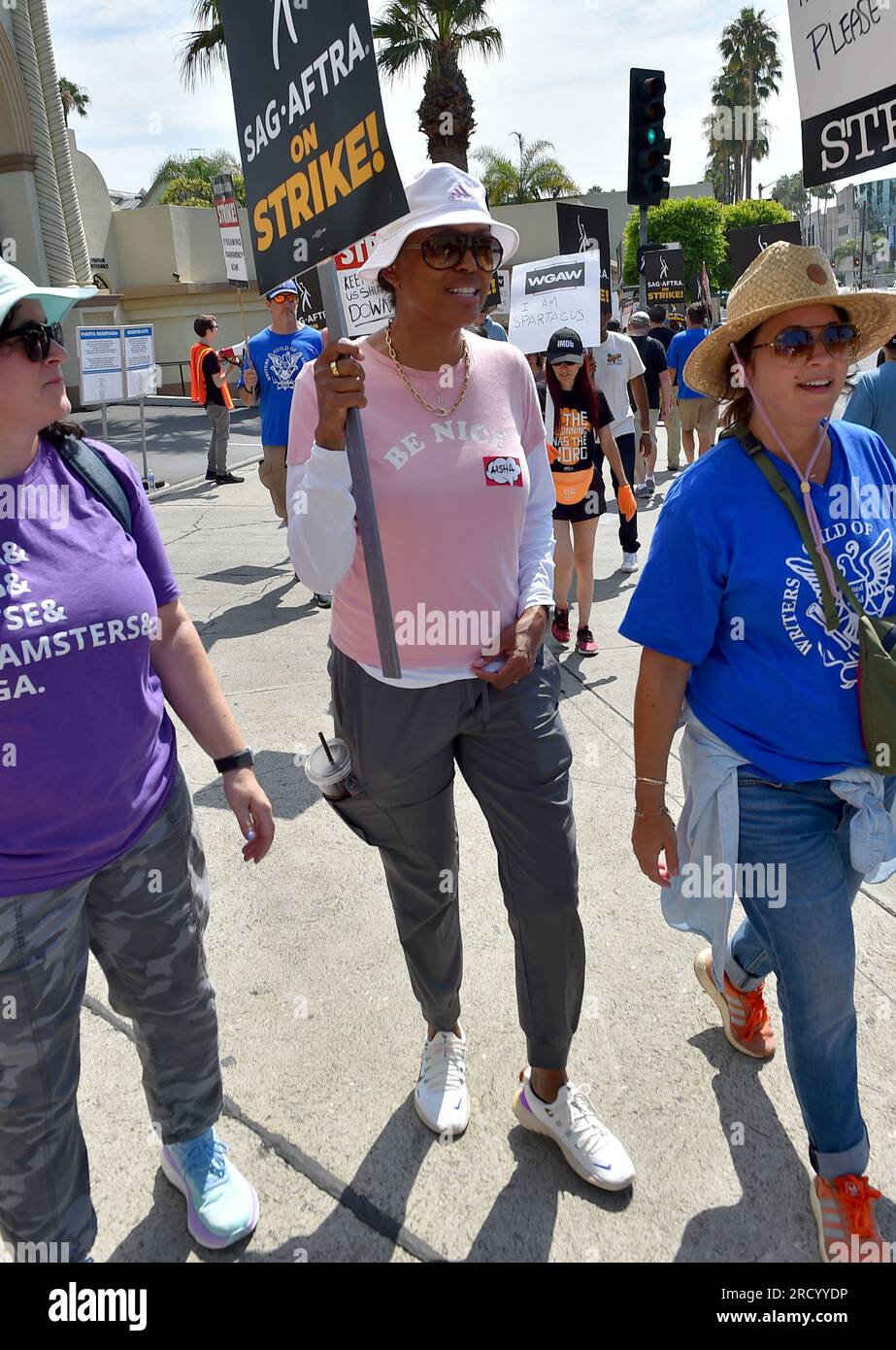 Actor Aisha Tyler, center, and fellow picketers carry signs outside ...
