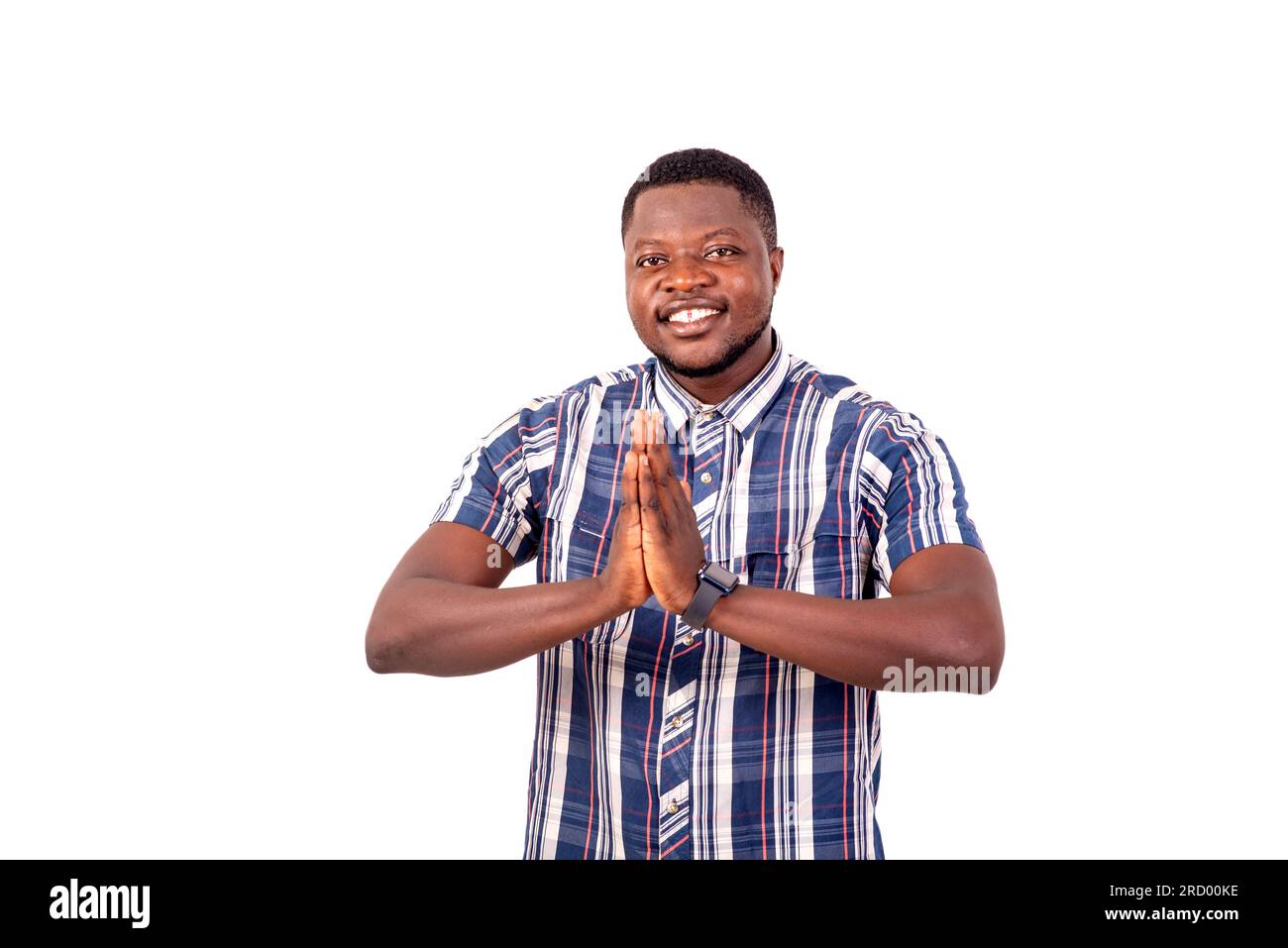 portrait of a satisfied handsome young man making prayer gesture with ...