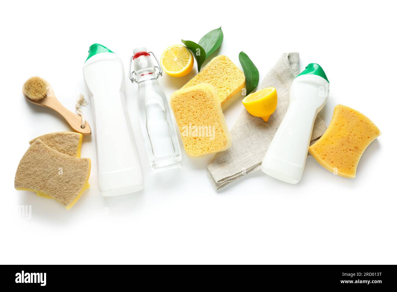 Bottles of vinegar, detergents, lemons, brush and sponges on white ...