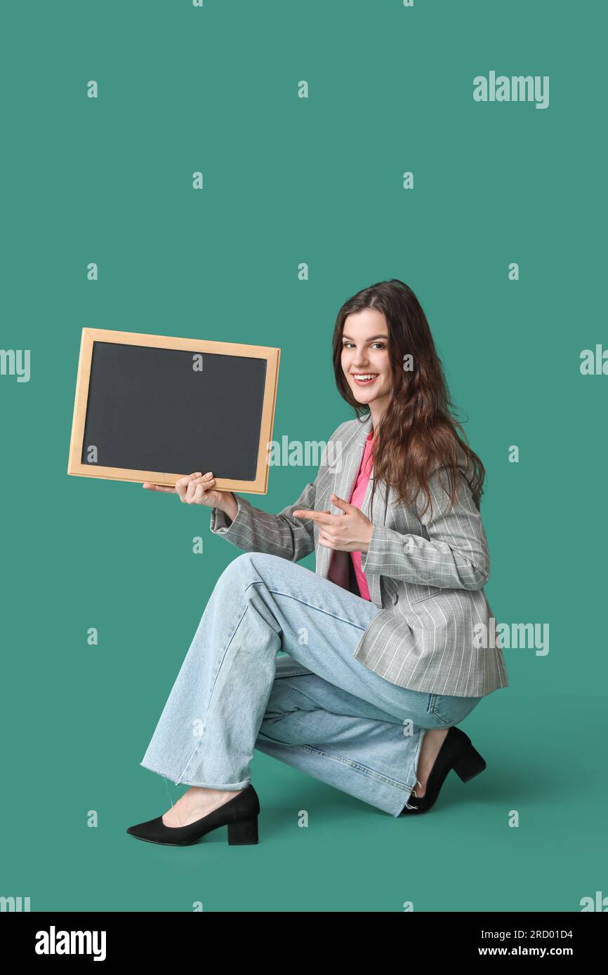 Female teacher with chalkboard on green background Stock Photo - Alamy