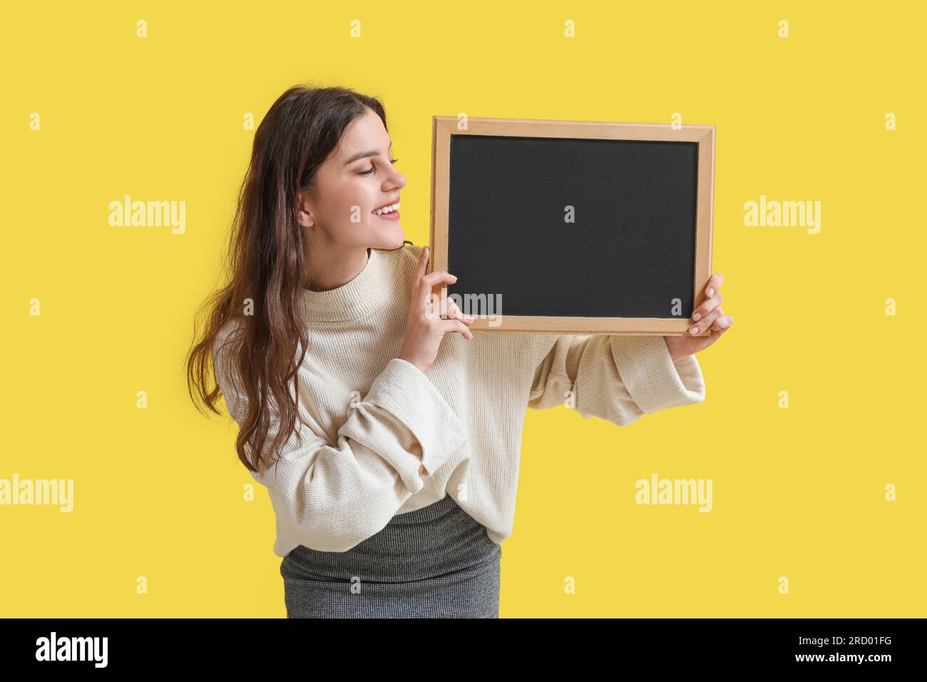 Female teacher with chalkboard on yellow background Stock Photo - Alamy