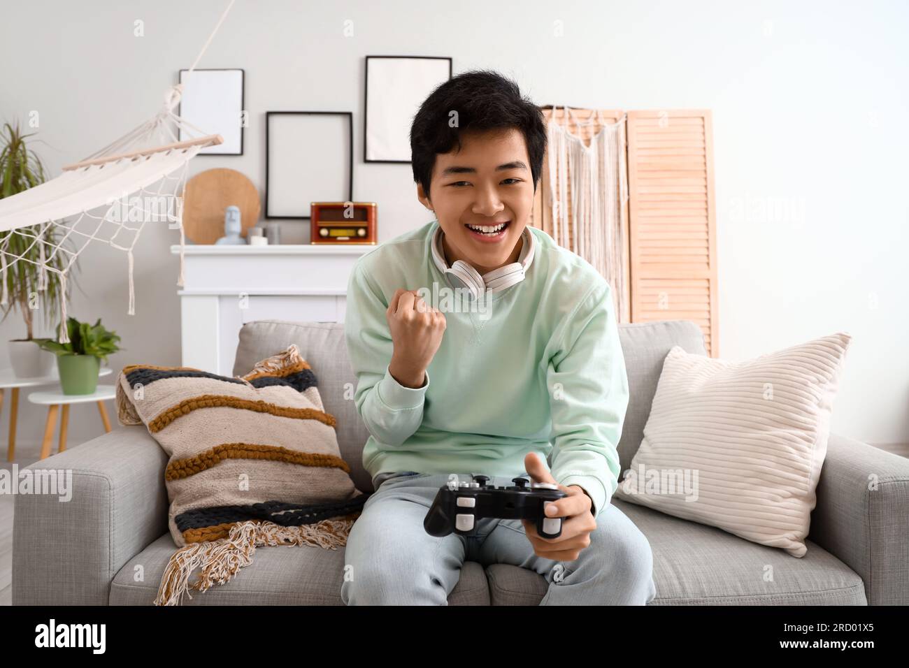 Young Asian man playing video game on his day off at home Stock Photo ...