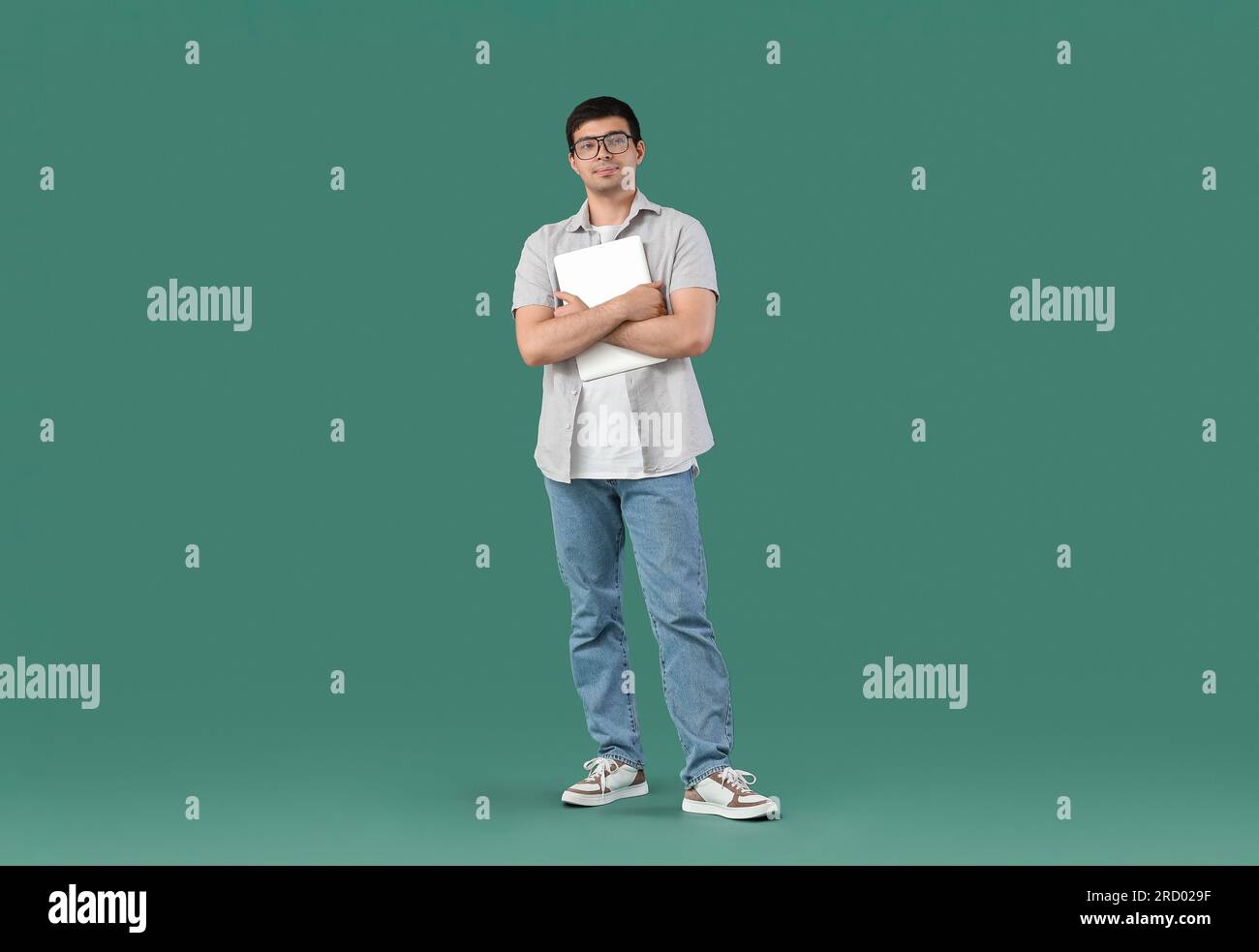 Male programmer with laptop on green background Stock Photo - Alamy
