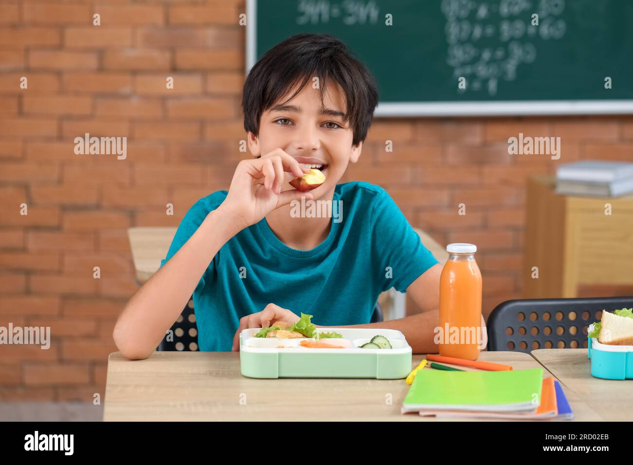 Little boy eating lunch in classroom Stock Photo - Alamy
