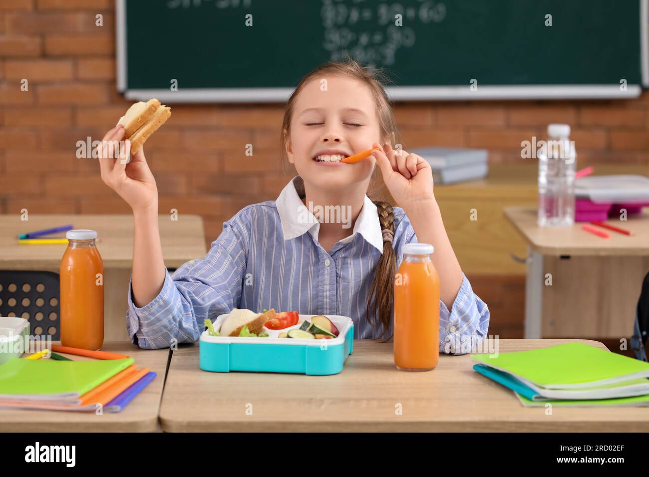 Little girl eating lunch in classroom Stock Photo - Alamy