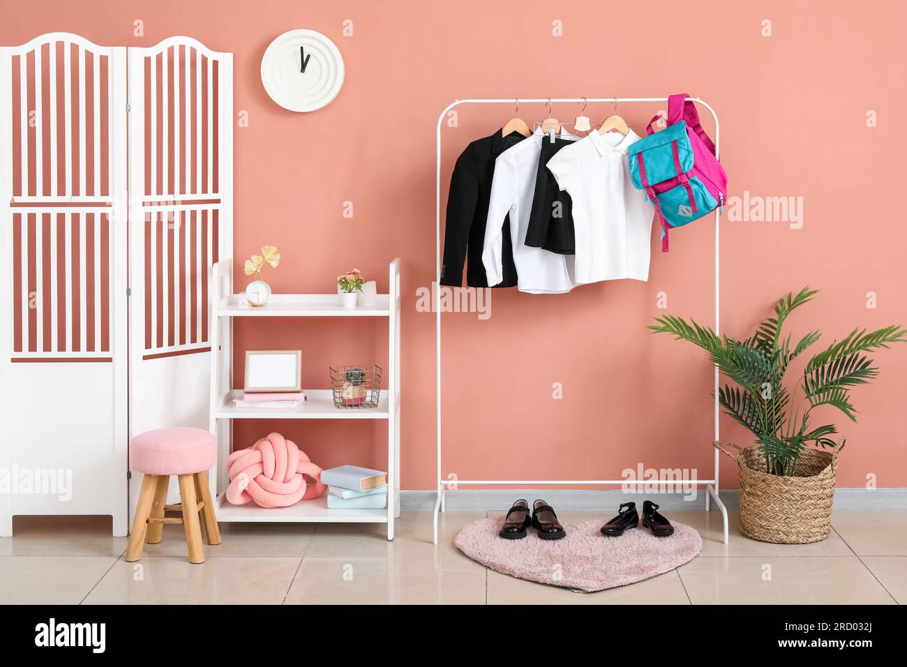 Rack with stylish school uniform, backpack, shoes, shelving unit and ...