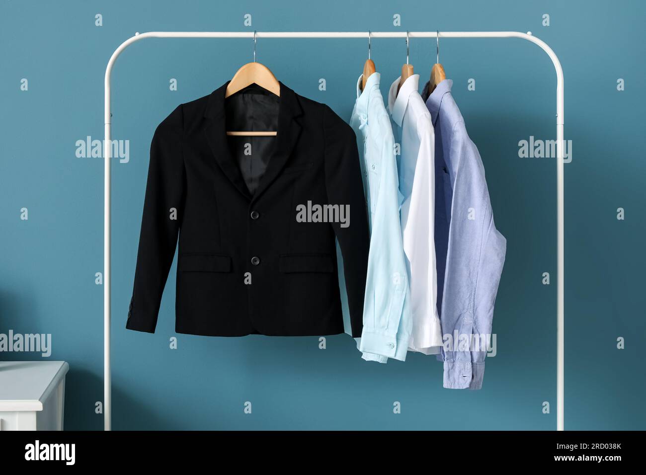 Rack with stylish school uniform against color wall, closeup Stock ...