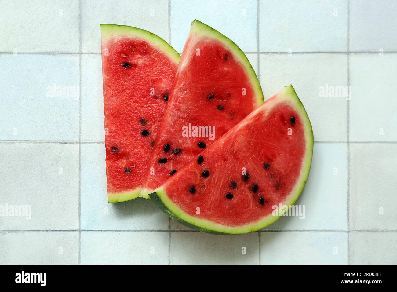 Pieces of fresh watermelon on white tile background Stock Photo - Alamy