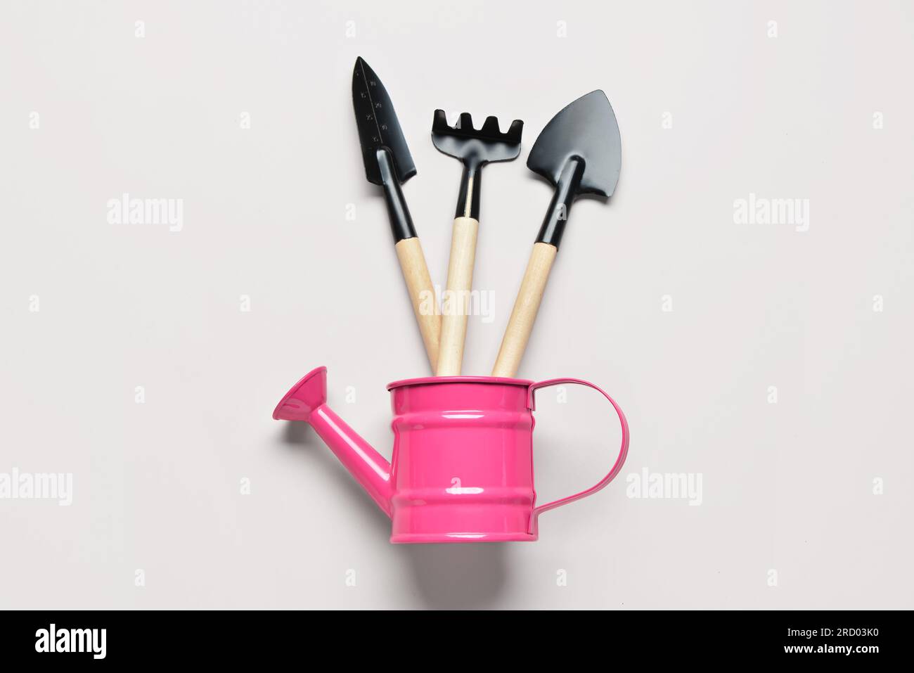 Watering can with gardening rake and shovels on white background Stock ...