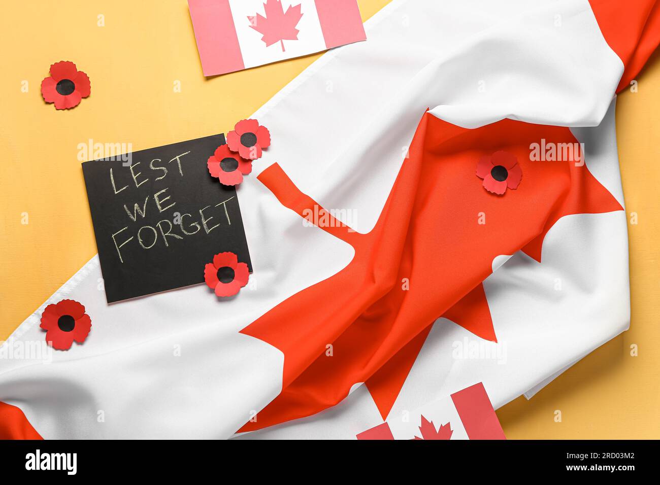 Poppy flowers with flags of Canada and card on orange background ...