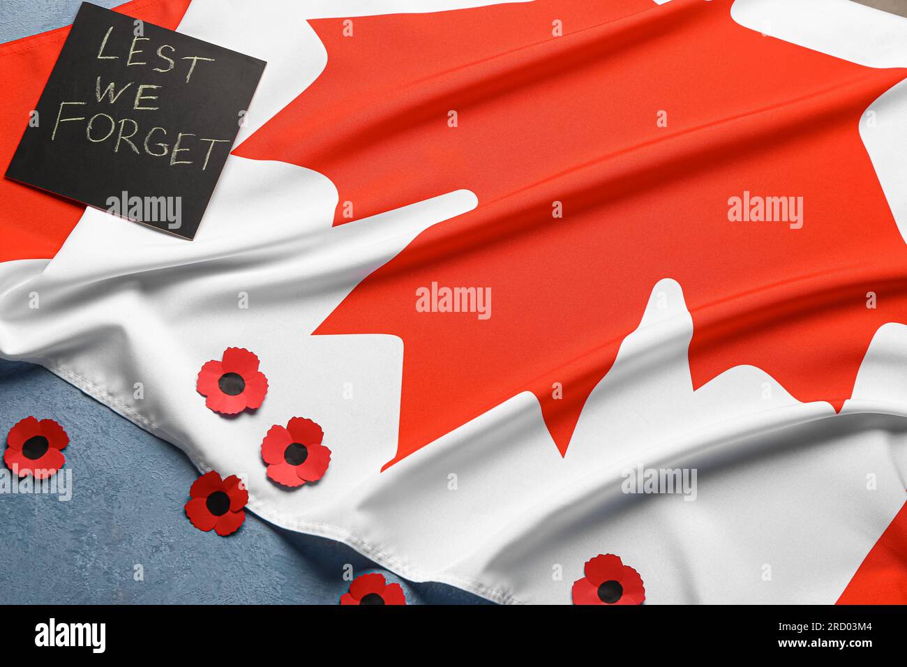 Poppy flowers with flag of Canada and card on grunge blue background ...