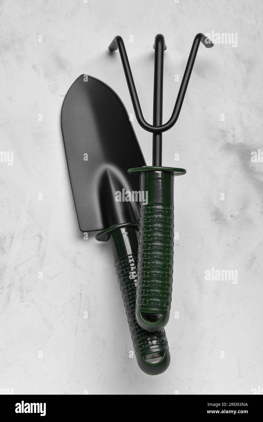 Gardening rake and shovel on white marble background Stock Photo - Alamy