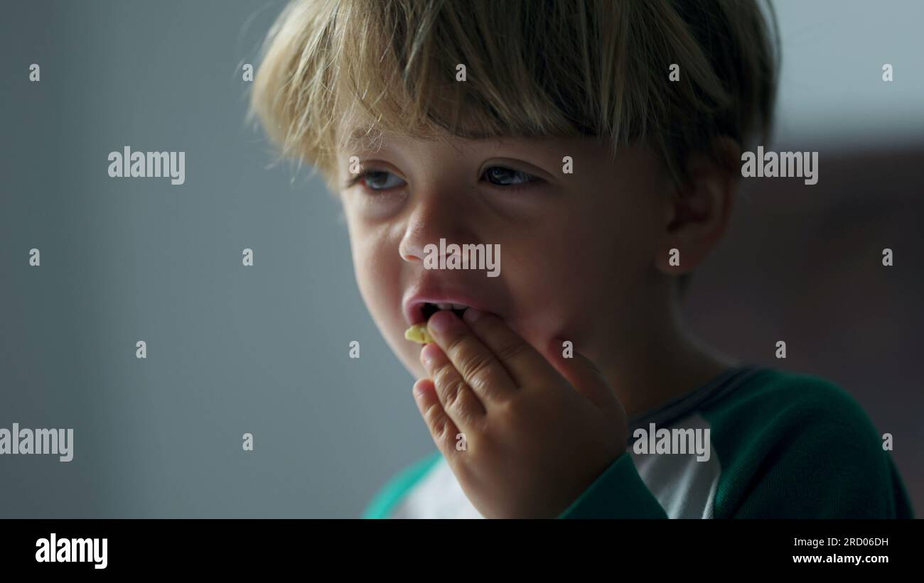 Child snacking portrait face kid eating cookie rice Stock Photo - Alamy