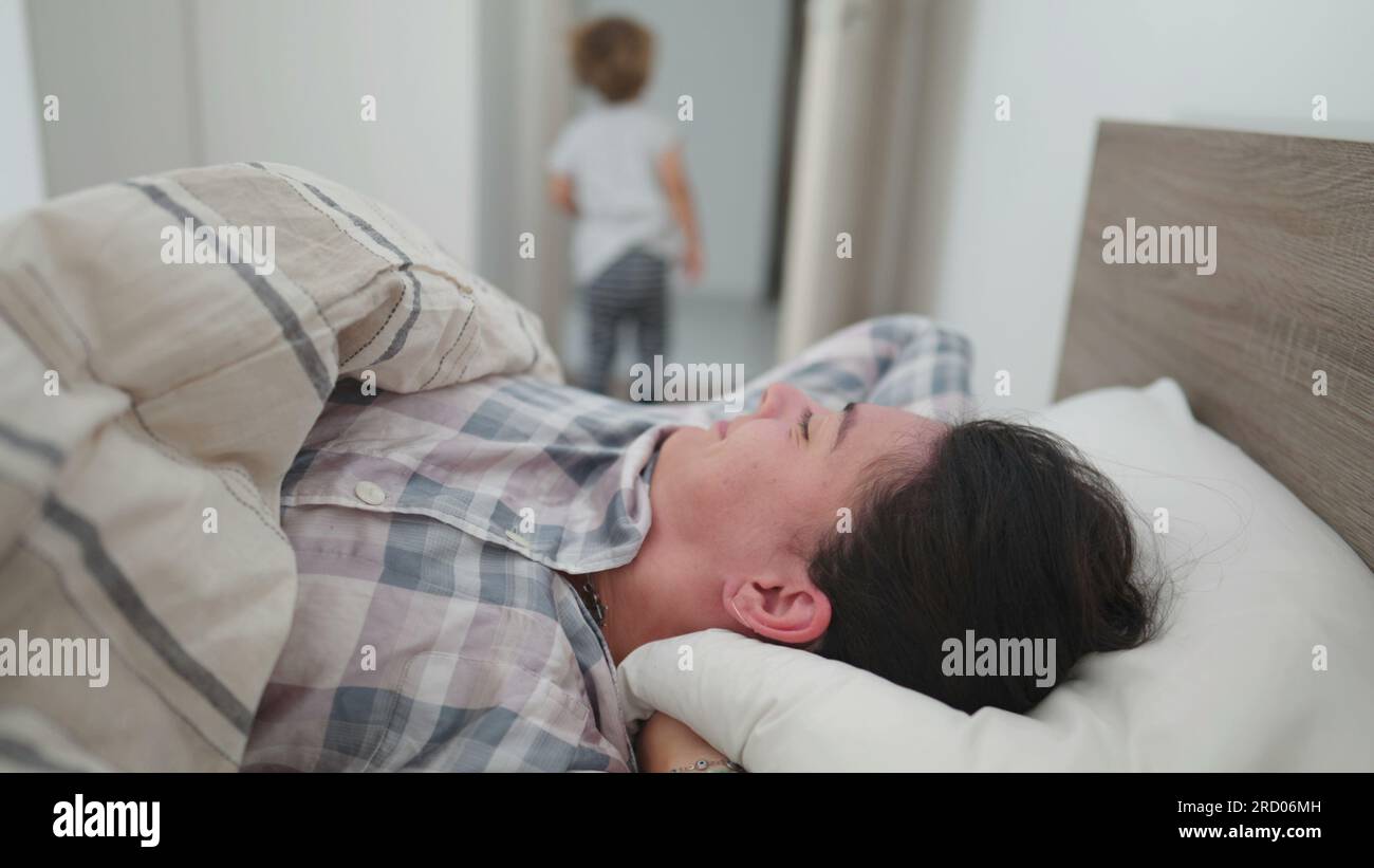 Mother wakes up in morning with child mom getting up from bed Stock ...