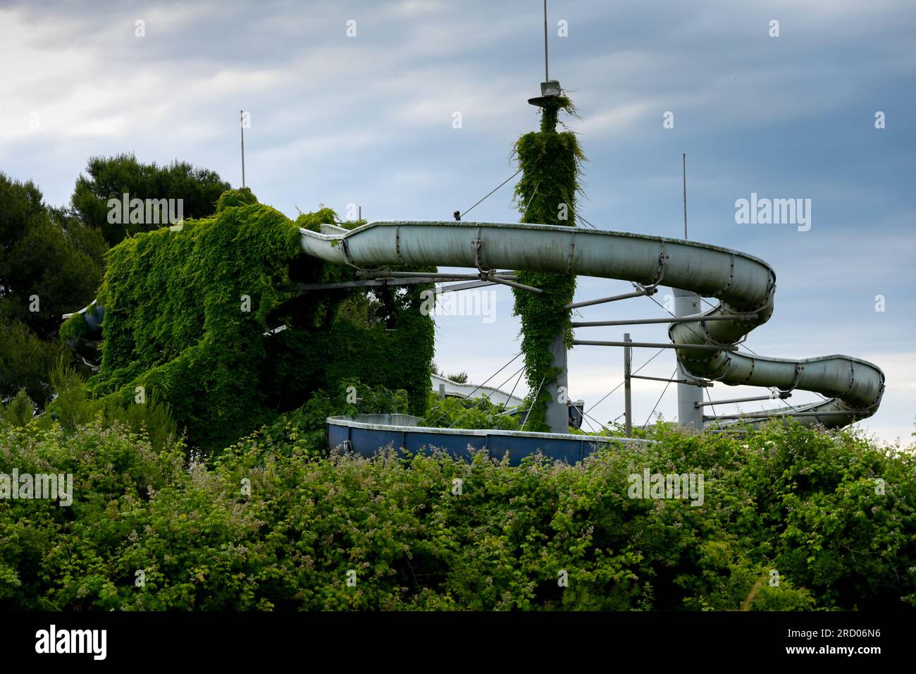old dilapidated abandoned lost place water slide overgrown with green ...
