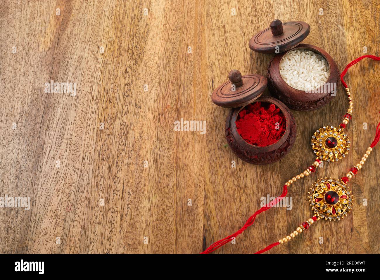 Raksha Bandhan background with Rakhi string, Rice Grains and Kumkum ...