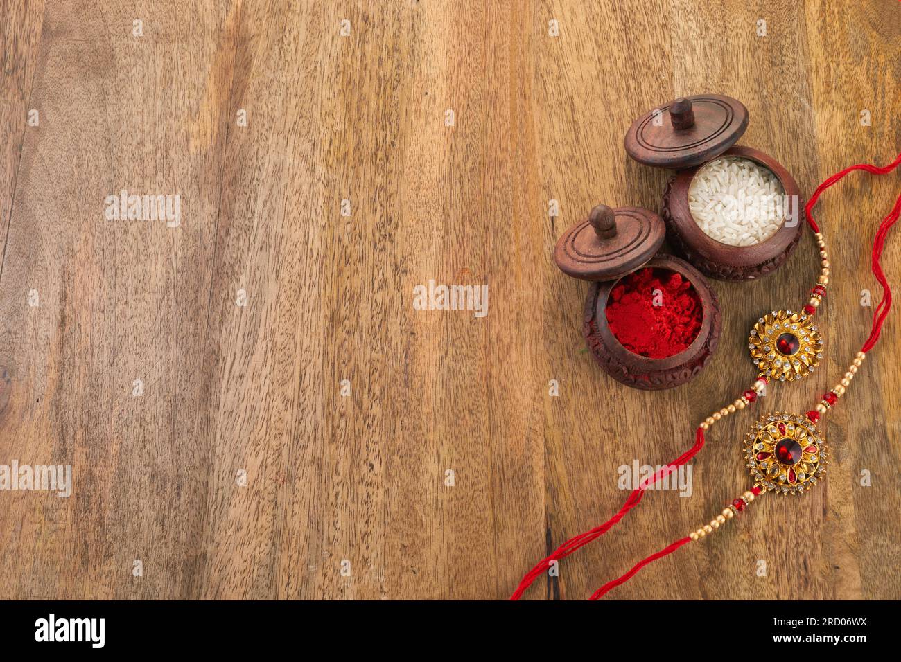 Raksha Bandhan background with Rakhi string, Rice Grains and Kumkum ...