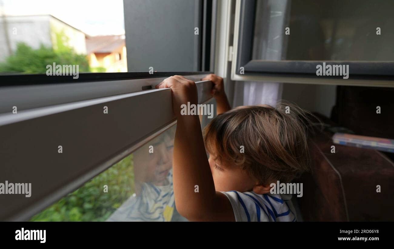 Child holding into window dangerous little boy near window wanting to ...